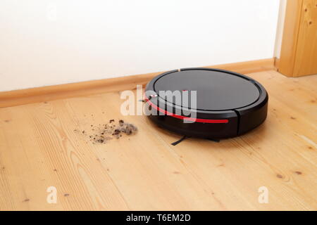 Robotic vacuum cleaner hoovering the floor at christmas Stock Photo - Alamy