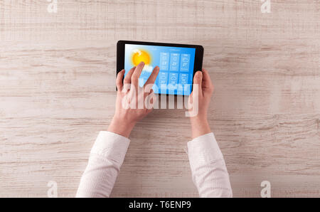 Man hand checking weekly weather forecast on tablet Stock Photo - Alamy