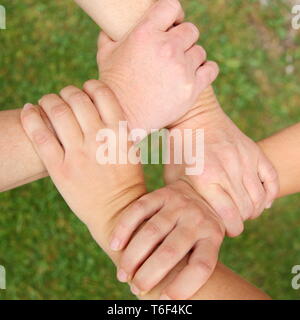 Four hands together, symbol of team work, isolated on a white ...