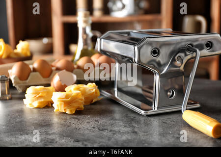 Metal pasta maker and products on kitchen table Stock Photo - Alamy