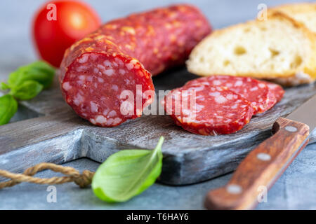 Salami sausage slices and green basil , selective focus Stock Photo - Alamy
