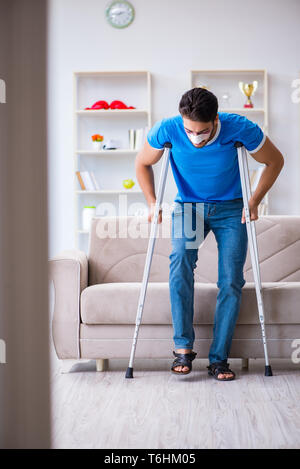 Injured man with crutches recovering at home Stock Photo - Alamy