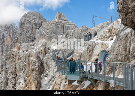 Austrian Dachstein Mountains with hikers passing a steel rope bridge ...