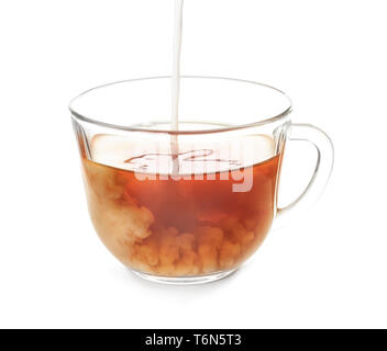 Adding milk to delicious tea on light background Stock Photo - Alamy