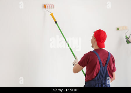 Male painter in uniform working indoors Stock Photo - Alamy