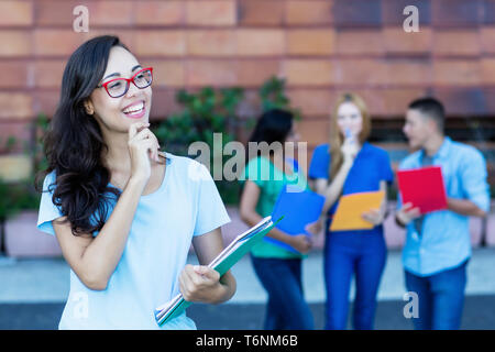 Nerdy female student with eyeglasses and group of international ...