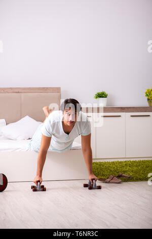The young man doing morning routine in bedroom Stock Photo - Alamy
