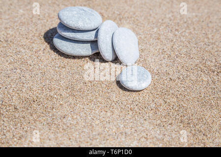 stack of pebble stones unbalanced on a sandy beach with copy space ...