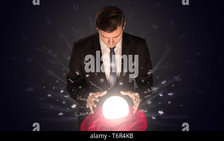 Gorgeous businessman looking to inspiration in a magic ball in his lap ...