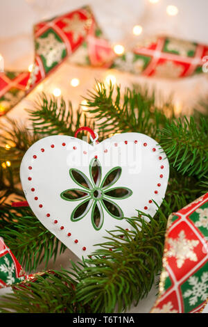 Silver Christmas heart hanging on a snow covered fir-tree branch Stock ...
