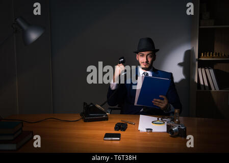 The detective sitting in dark room in vintage concept Stock Photo - Alamy
