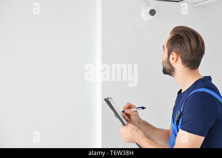 Electrician inspecting surveillance camera Stock Photo - Alamy