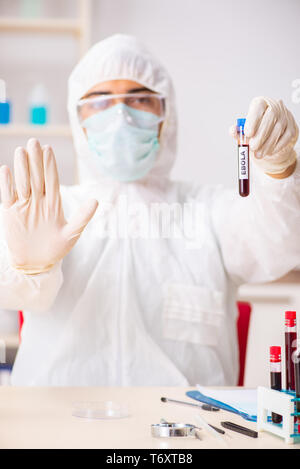Young handsome lab assistant testing blood samples in hospital Stock ...