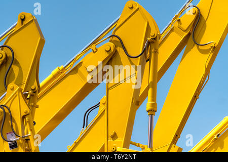 Yellow backhoe loader against clear blue sky Stock Photo - Alamy