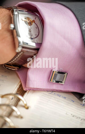 Elegant man with expensive watch on his hand stands reception desk ...