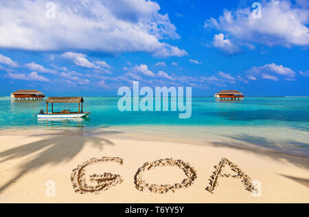 Text GOA on the sand on the beach on the background of blue sea and ...