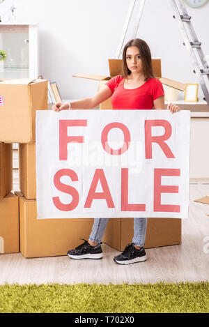 Young beautiful woman selling flat Stock Photo - Alamy