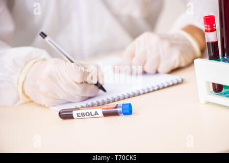 Young handsome lab assistant testing blood samples in hospital Stock ...