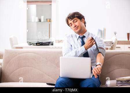 Man under stress measuring his blood pressure Stock Photo - Alamy