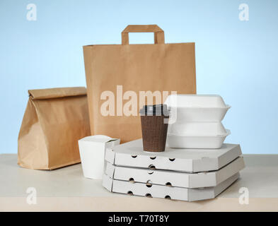 Different packages on table against color background. Food delivery ...