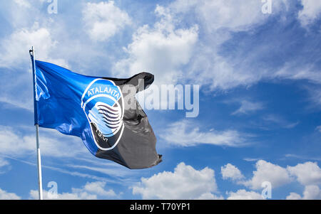 Atalanta flag waving against blue sky with white clouds. Space for text ...