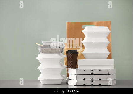 Different packages on table against color background. Food delivery ...