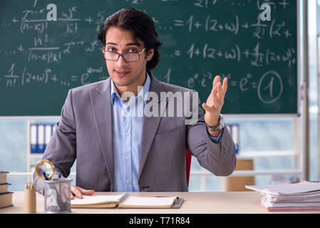 Young handsome math teacher in classroom Stock Photo - Alamy