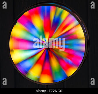 Colorful rainbow pinwheel wind spinner with polka dot pattern on a ...
