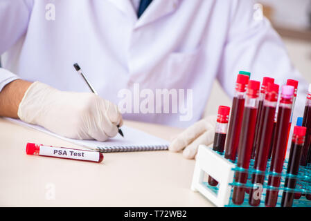 Young handsome lab assistant testing blood samples in hospital Stock ...
