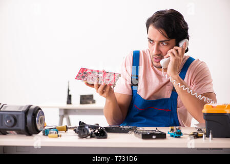 Young male contractor repairing computer Stock Photo - Alamy