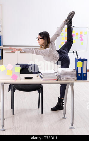 Young female employee doing exercises in the office Stock Photo - Alamy