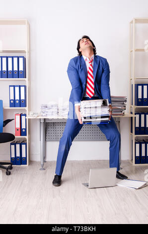 Young businessman employee unhappy with excessive work at workplace ...