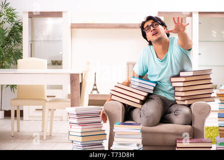 Male student with many books at home Stock Photo - Alamy