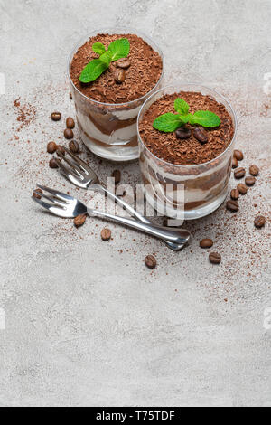 two portions Classic tiramisu dessert in a glass isolated on a white ...