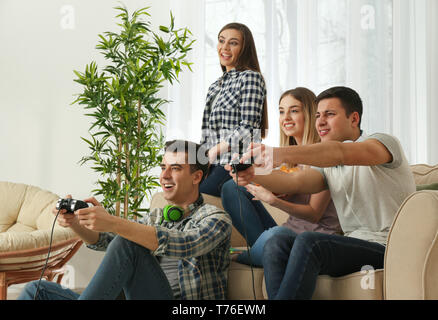 Group of excited friends playing video games at home. Caucasian male ...