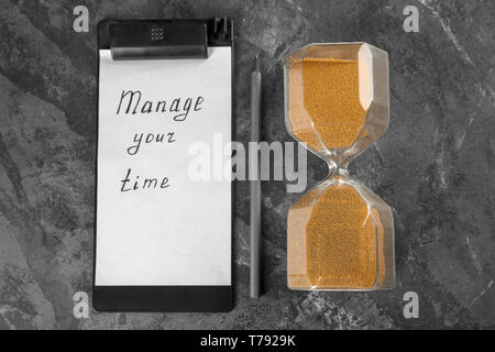 Hourglass with clipboard and pencil on grey textured background. Time ...