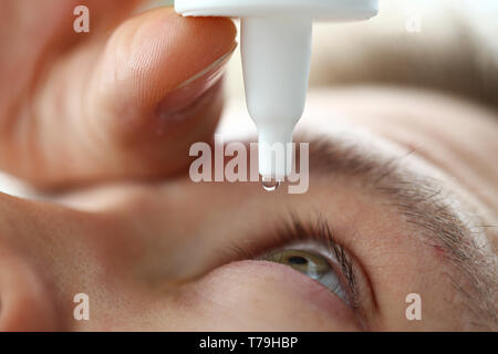 Man putting liquid drops in his eye solving vision problem Stock Photo ...