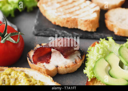 Different delicious toasts on table Stock Photo - Alamy