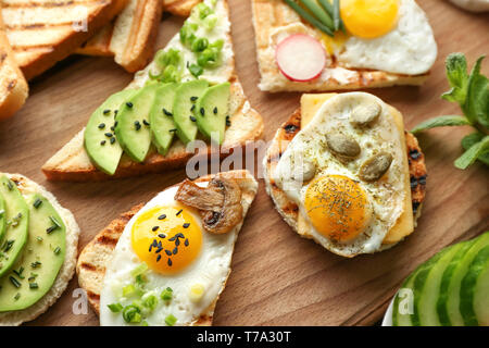 Board with different delicious toasts on table, closeup Stock Photo - Alamy