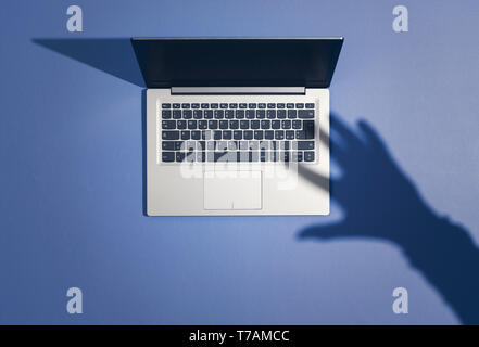 Threatening hand attacking a laptop and stealing information: cyber ...