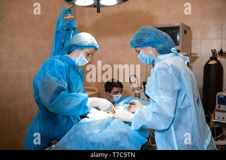 veterinarian or doctors doing surgery in the clinic. medicine, pet ...