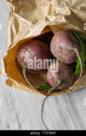 Organic beetroot in a brown paper bag on grey wood. Recycle packaging ...