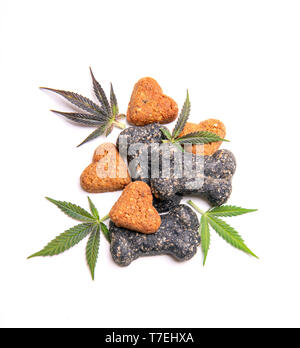 Dog treats and cannabis leaves isolated over white background - CBD and ...