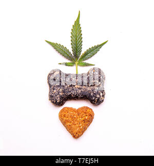 Dog treats and cannabis leaves isolated over white background - CBD and ...