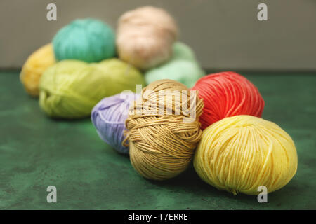 Colorful yarns and knitted clothes on table indoors Stock Photo - Alamy
