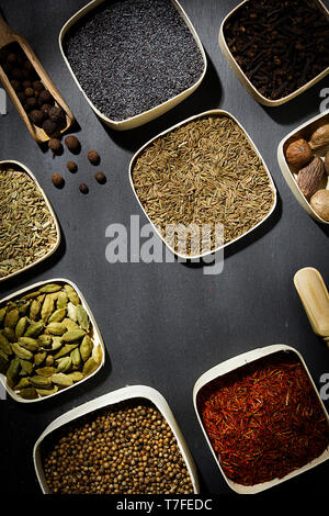 Collection of spices: sweet peas, black pepper, guzica in wooden spoons ...