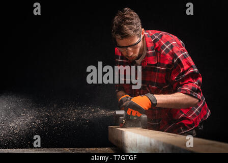 Carpenter works with electrical planer in workshop Stock Photo - Alamy