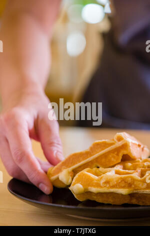 woman hands prepare waffle for serving process.waffle made from dough ...