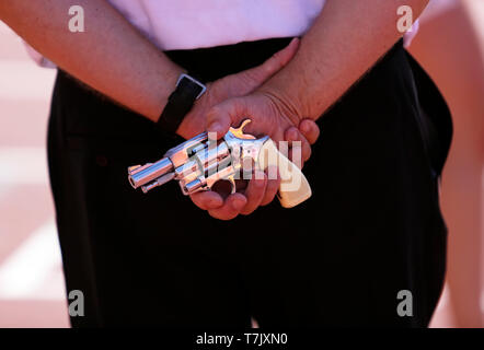 Race official holding a starting gun at the beginning of a track event ...