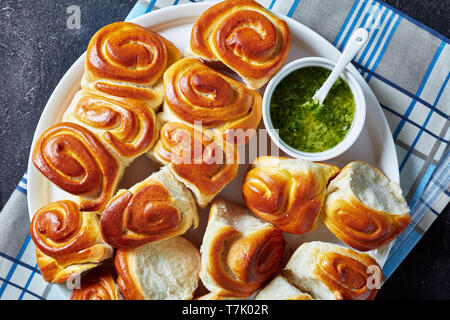 Fresh baked garlic buns and wheat ears on light gray table Stock Photo ...